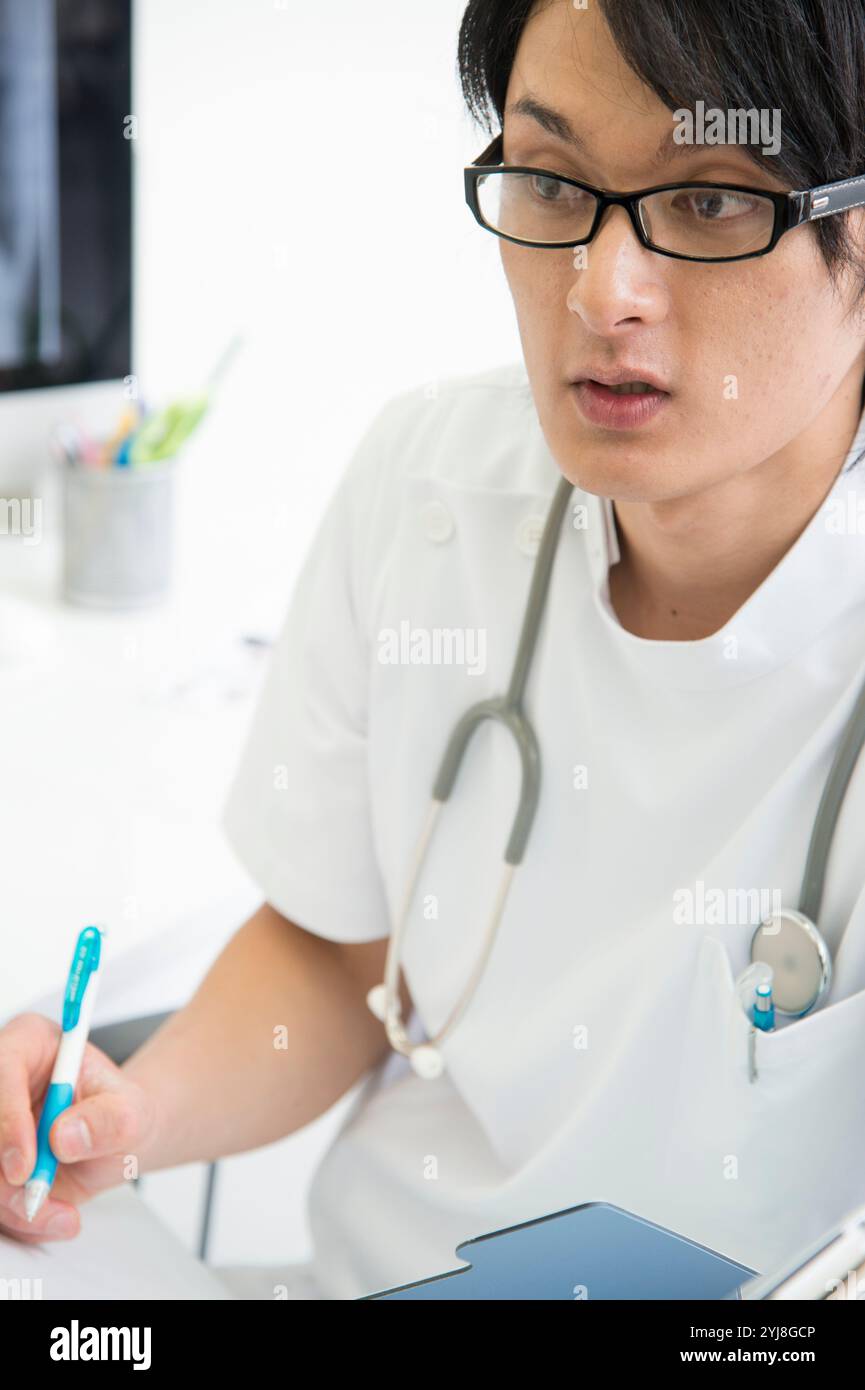 Doctor looking at file Stock Photo - Alamy