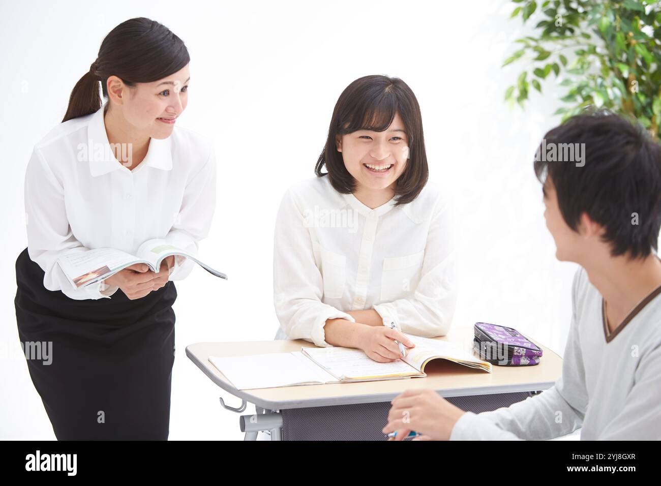 High school students and female teachers in class at a cram school ...
