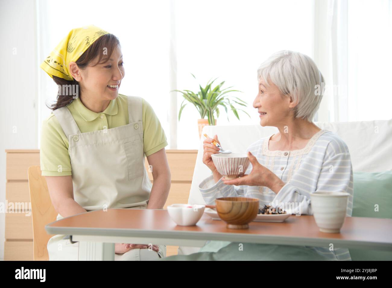 Care helper feeding an elderly person in a care bed Stock Photo - Alamy