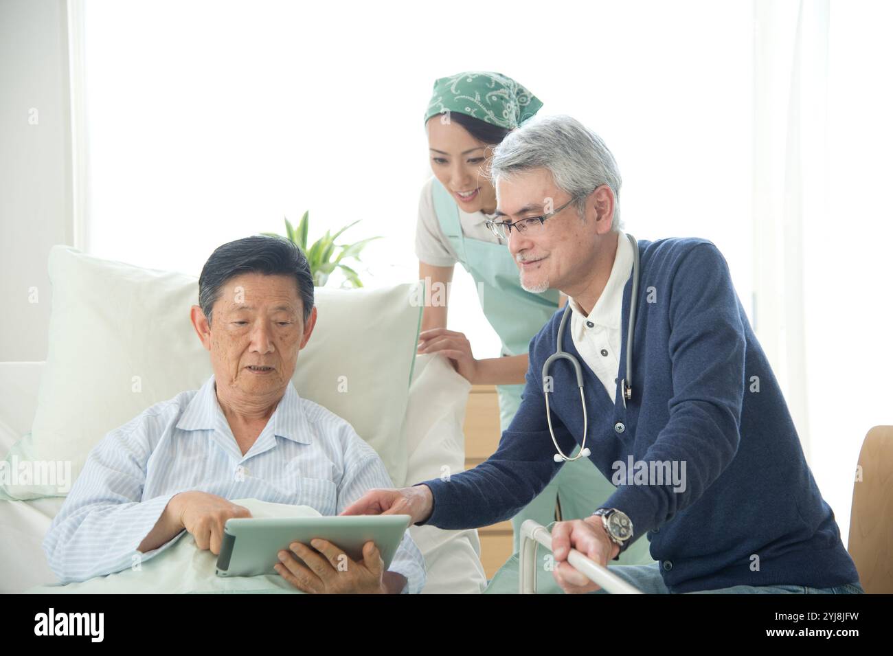 Doctor and care helper examining an elderly person in a care bed Stock ...