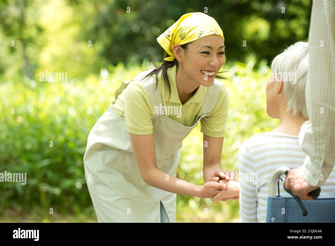 Elderly couple in wheelchair and care helper Stock Photo - Alamy