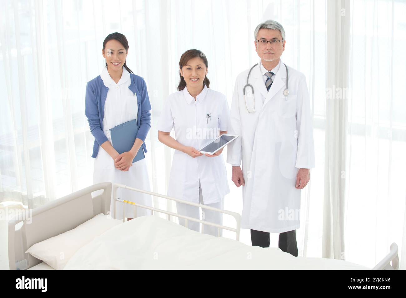 Doctor and nurse standing in front of hospital bed Stock Photo - Alamy