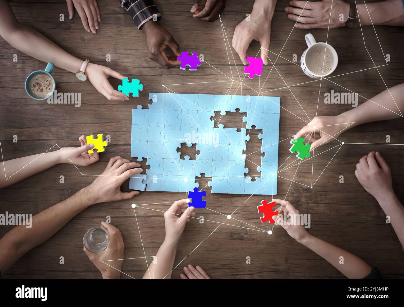 People putting puzzle pieces together on wooden table, top view. Scheme ...
