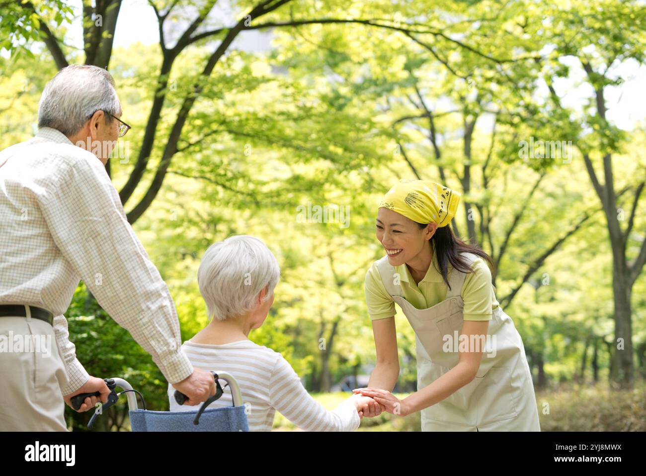 Elderly couple in wheelchair and care helper Stock Photo - Alamy