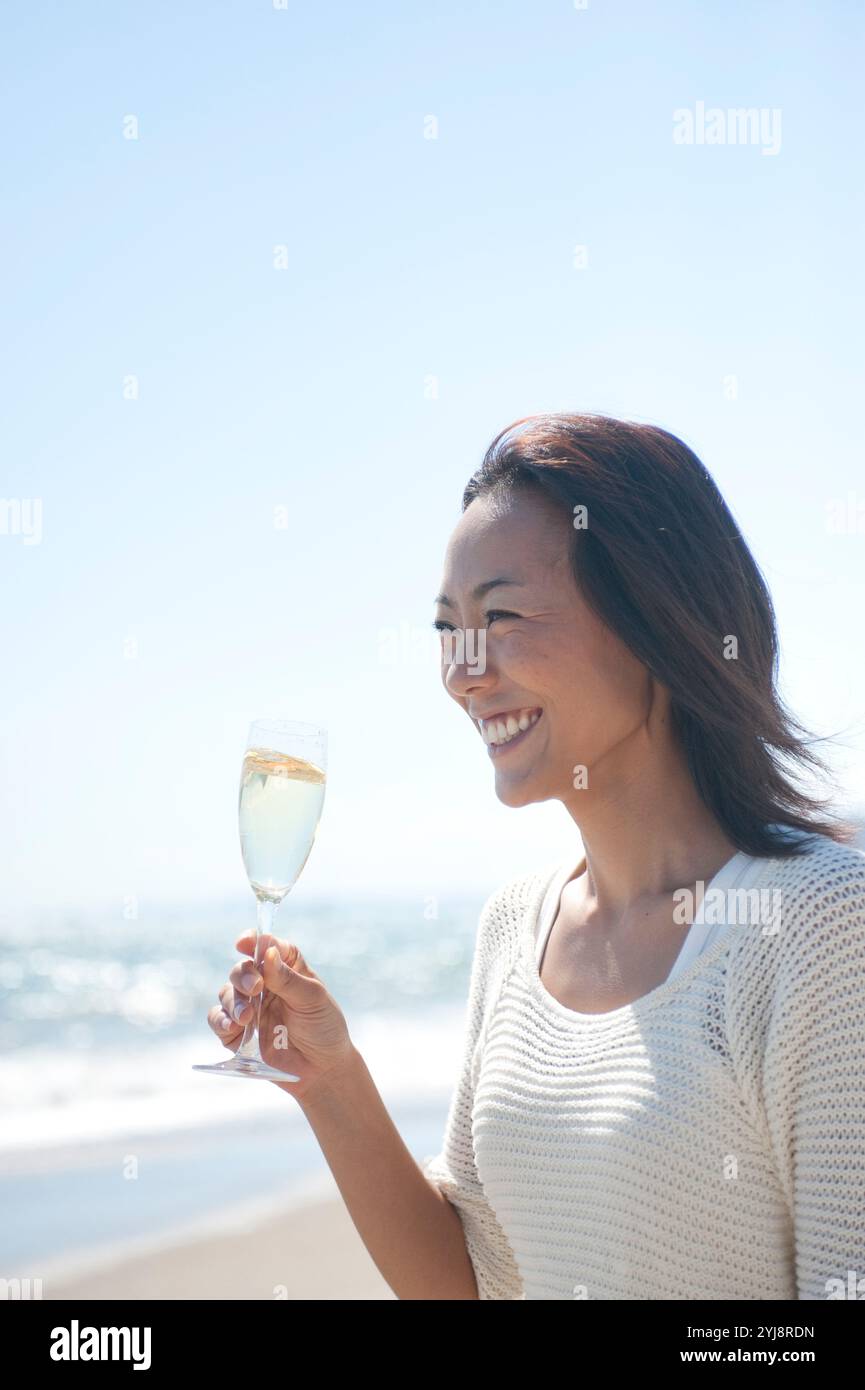 Woman drinking champagne on the beach Stock Photo - Alamy
