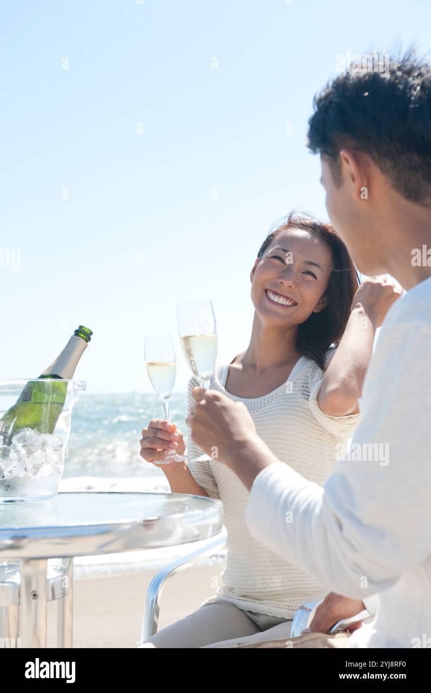 Couple drinking champagne on the beach Stock Photo - Alamy