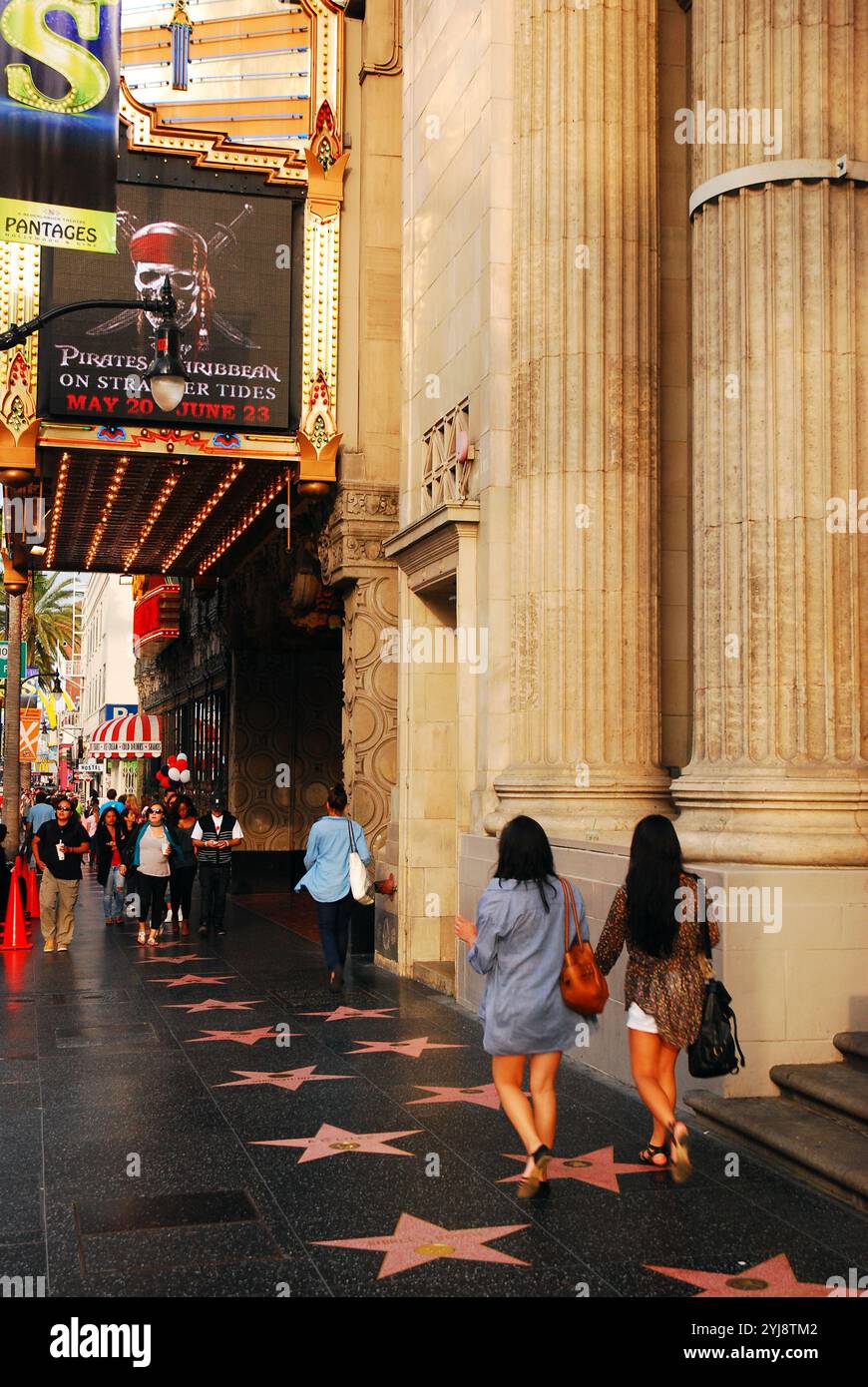 Two women walk under the marquee of the El Capitan theater, with the ...