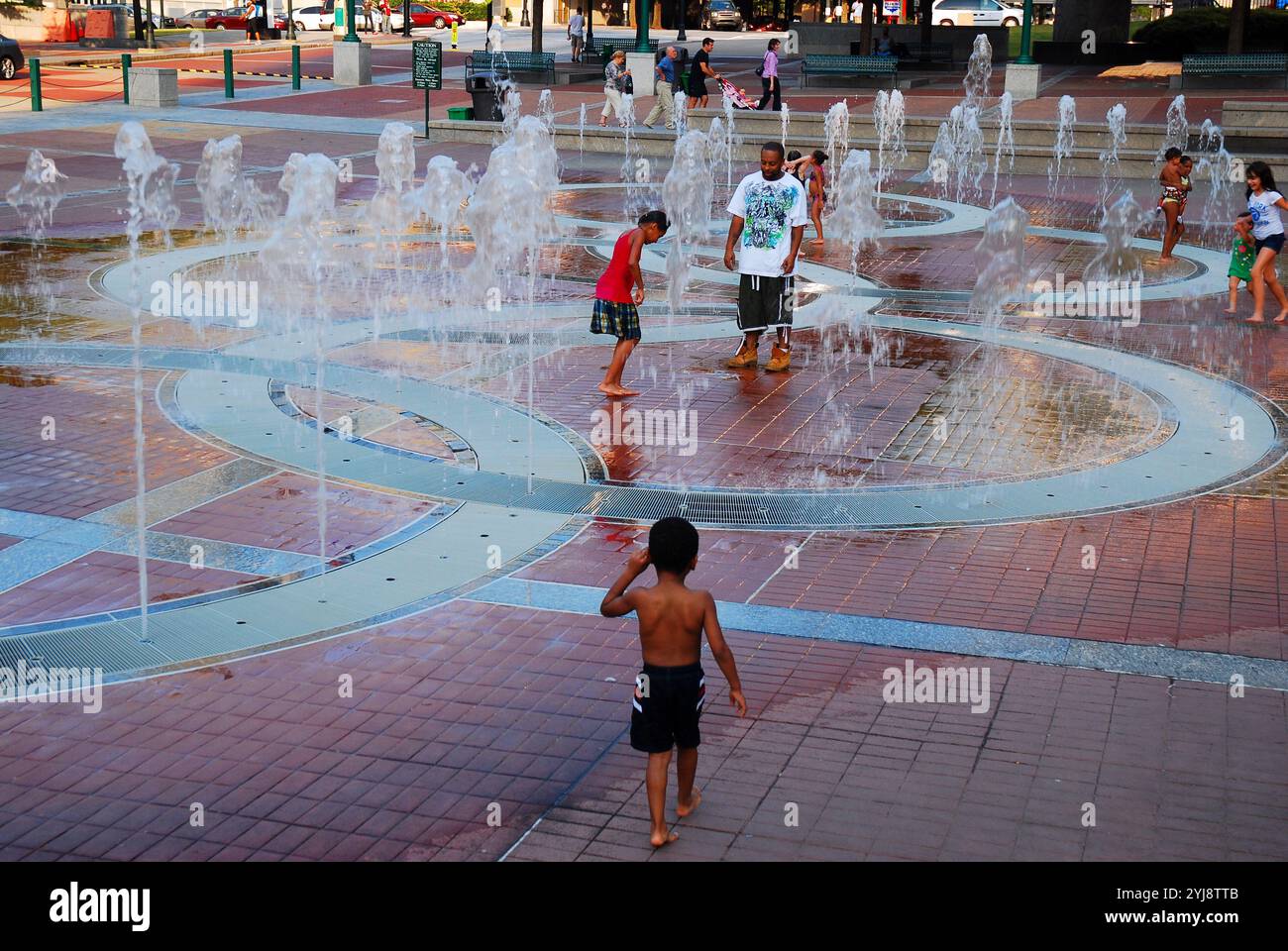 On a warm summer day in Centennial Park in Atlanta, a family cools off ...