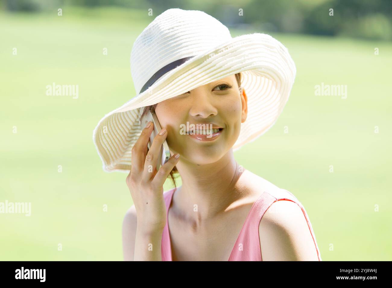 Woman in white hat making a mobile phone call Stock Photo - Alamy
