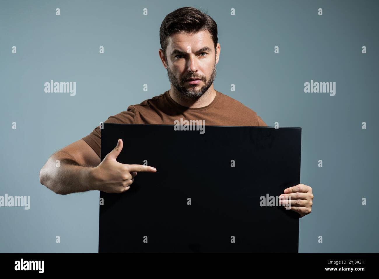 Man in studio showing promo blank board pointing finger on sign board ...