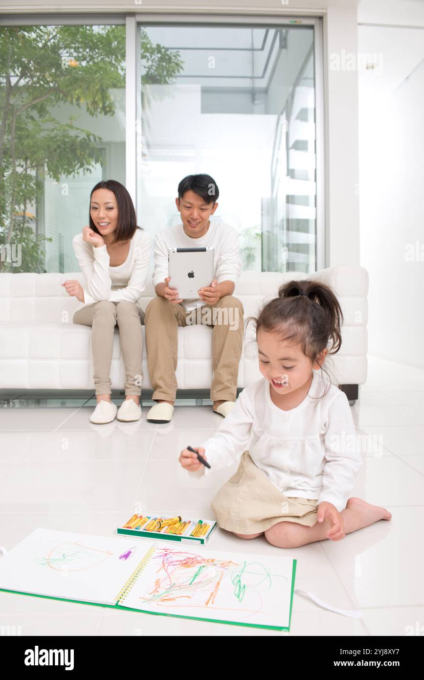 Girl and parents drawing in living room Stock Photo - Alamy