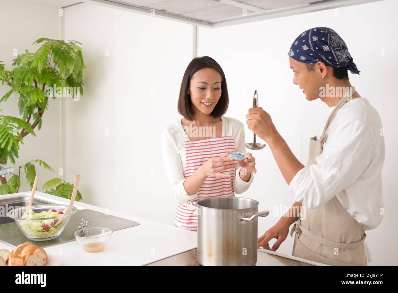 Couple in their 20s cooking in the kitchen Stock Photo - Alamy