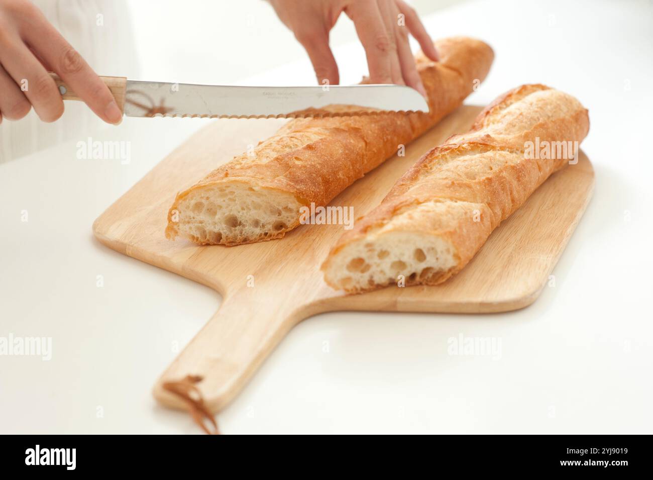 Hand cutting bread knife hi-res stock photography and images - Alamy