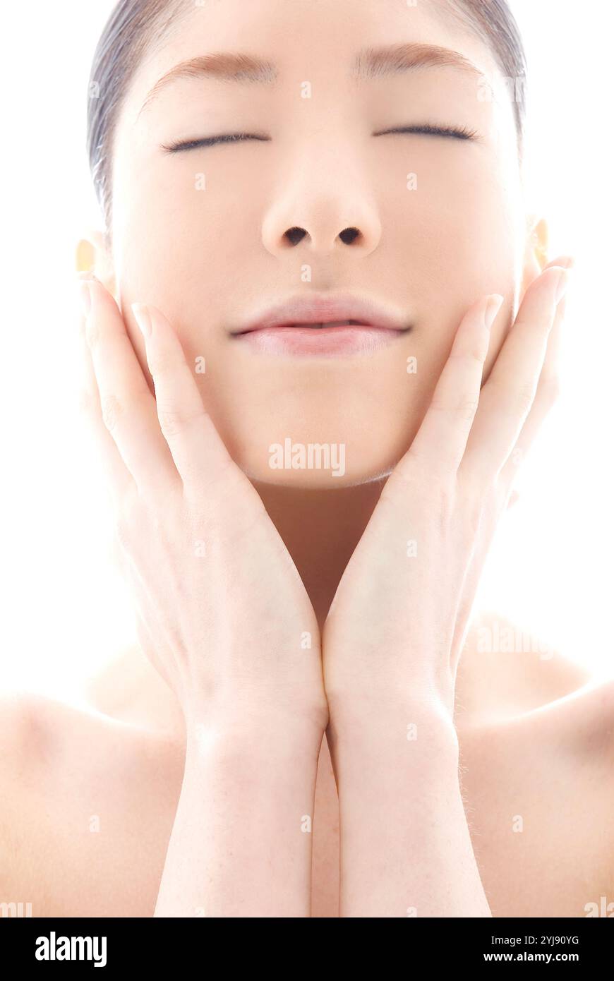 Japanese woman in her teens patting her cheek Stock Photo - Alamy