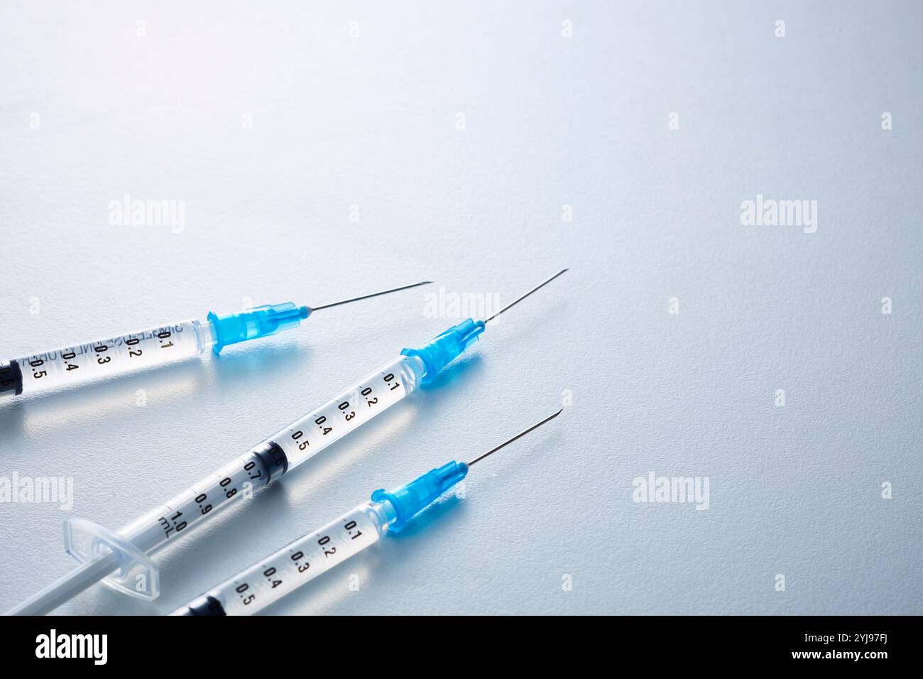 Three syringes on white baking sheet Stock Photo - Alamy