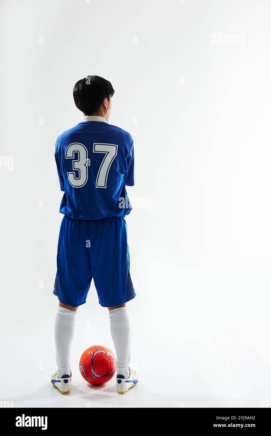 Back view of footballer with arms folded in front of football Stock ...