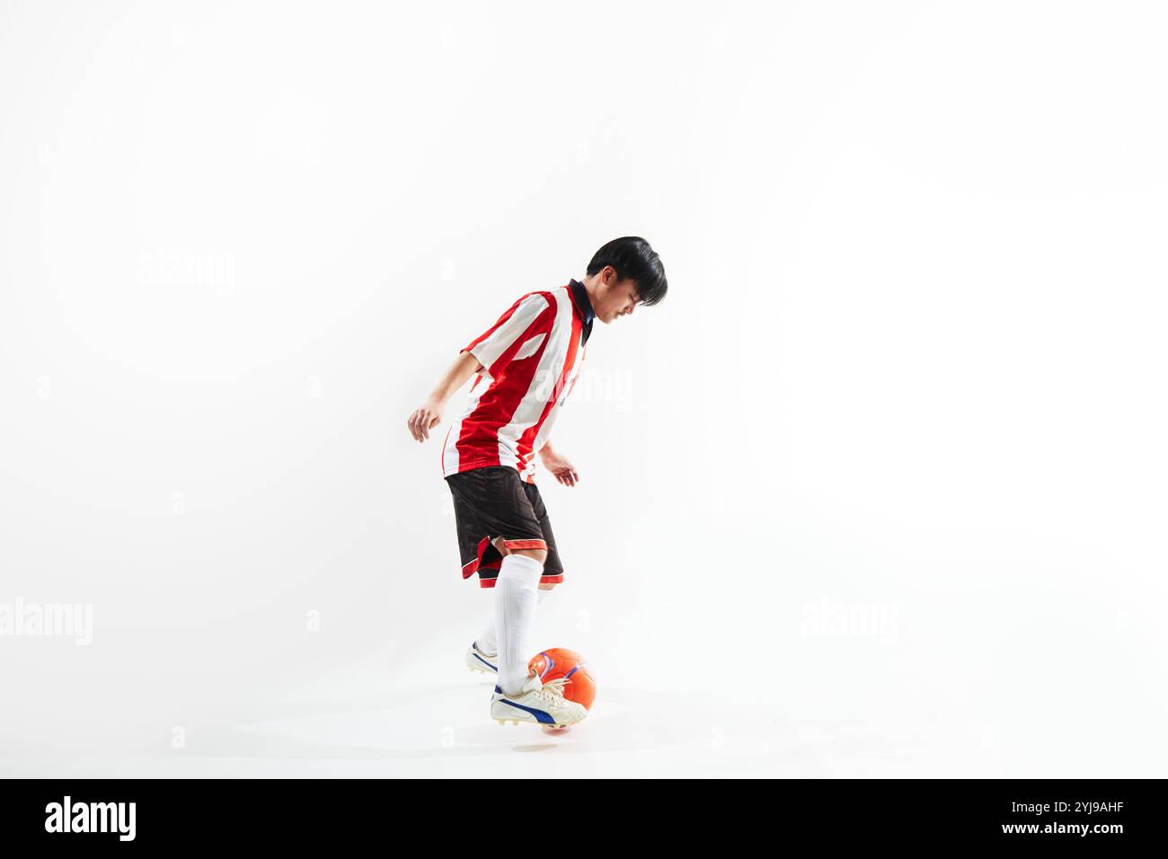 Footballer kicking a ball Stock Photo - Alamy