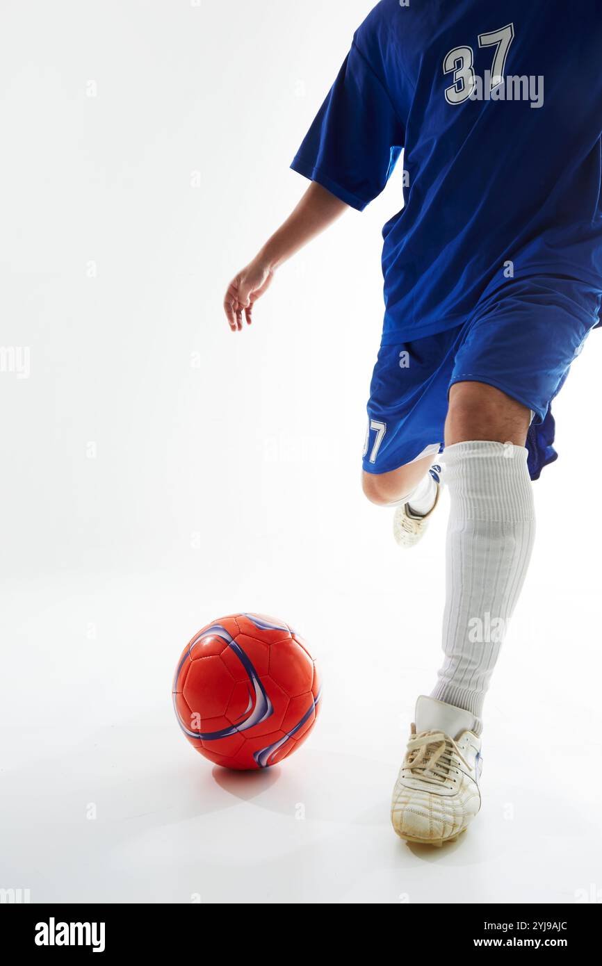 Footballer trying to kick a ball Stock Photo - Alamy