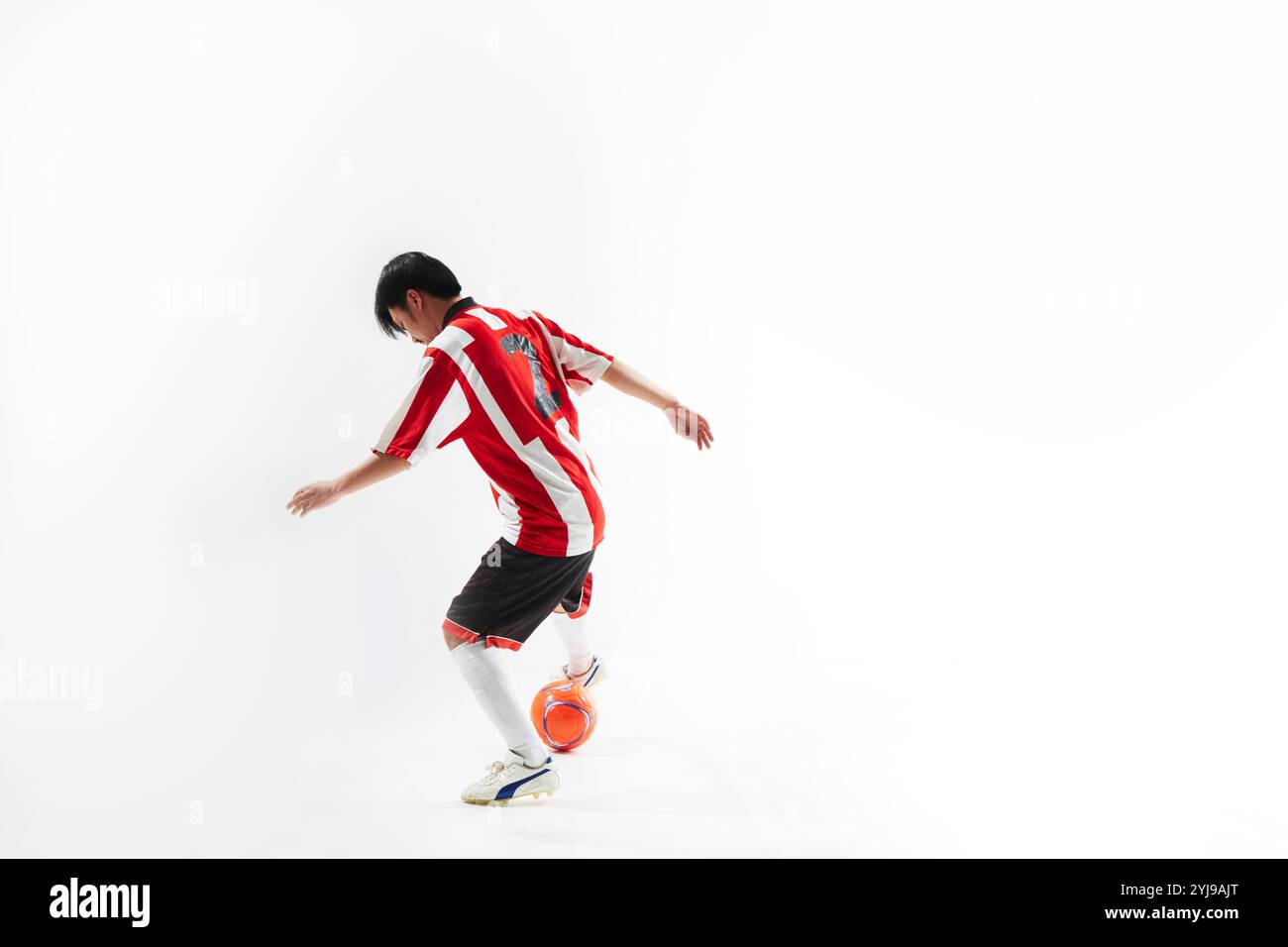 Footballer kicking a ball Stock Photo - Alamy