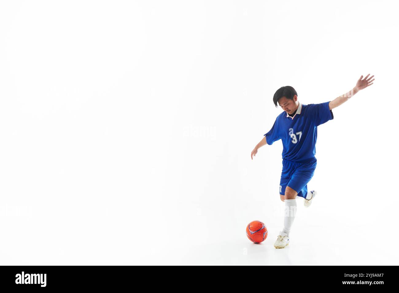 Footballer kicking a ball Stock Photo - Alamy