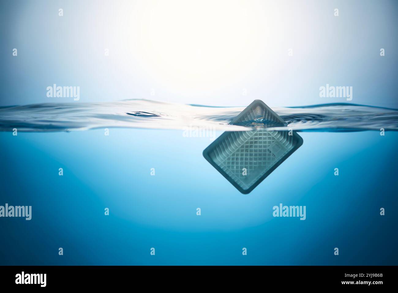 Plastic waste floating on water Stock Photo - Alamy