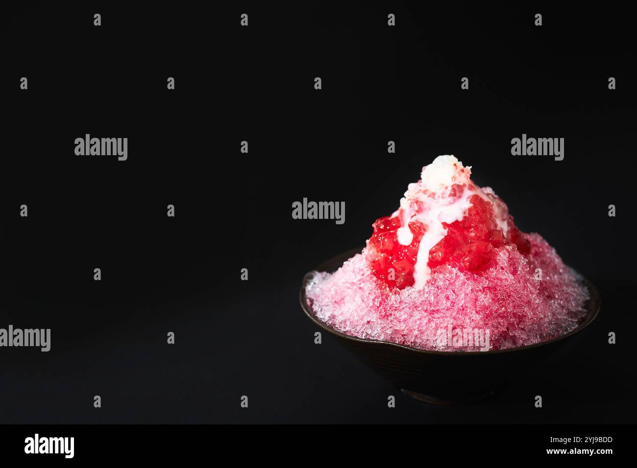 Red shaved ice with condensed milk floating in a black space Stock ...