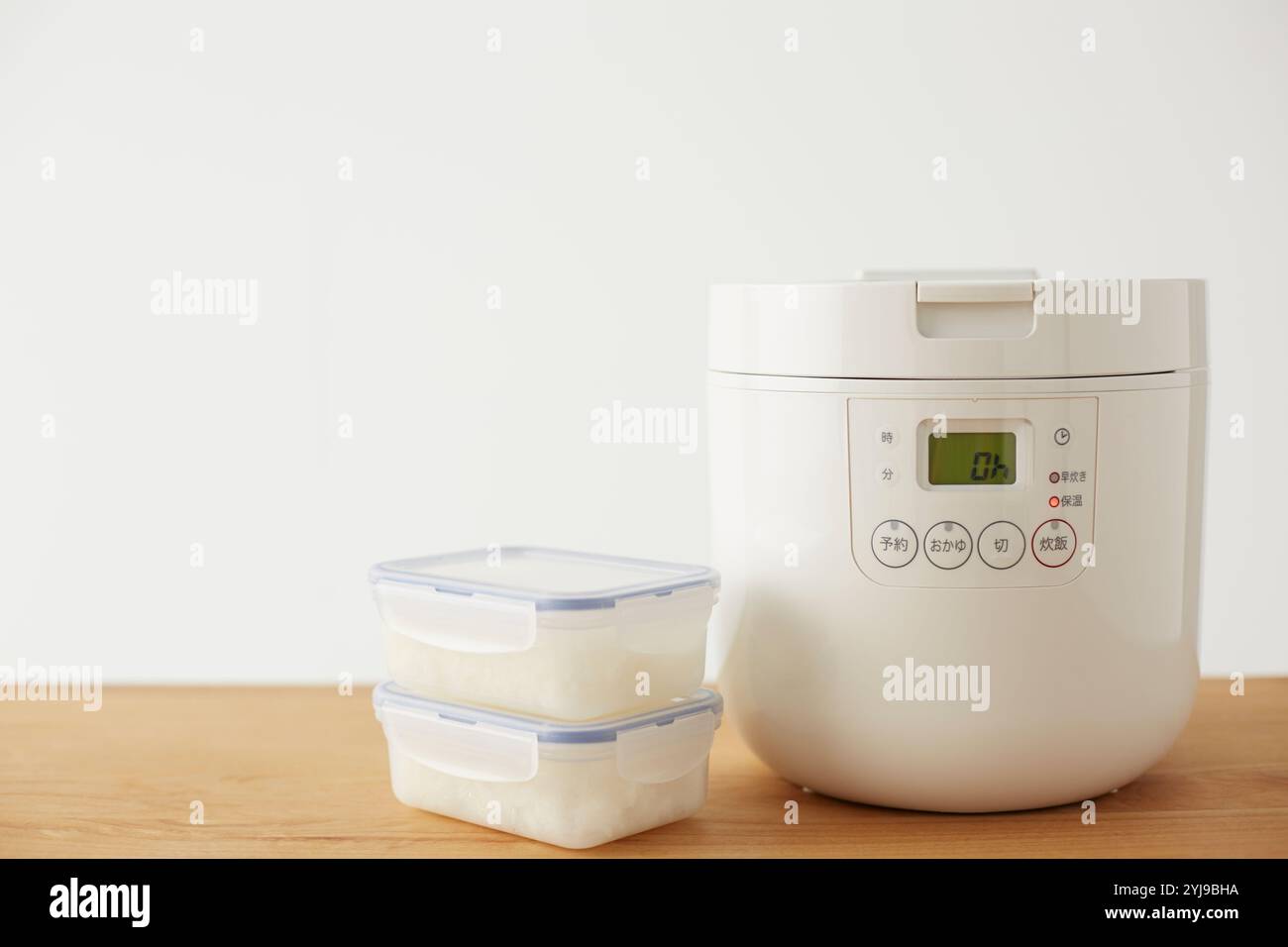 Cooked rice and small portion of white rice in Tupperware Stock Photo ...