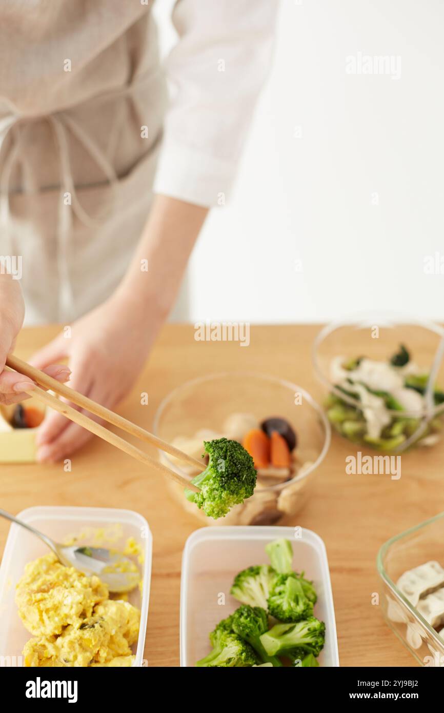 Woman packing food in Tupperware into a lunchbox Stock Photo - Alamy