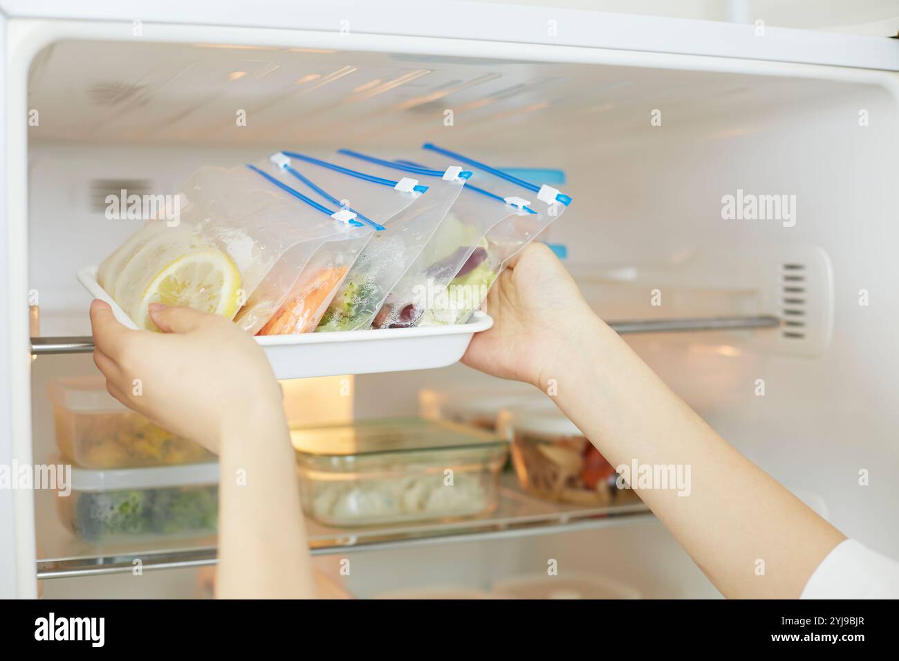 Person taking out small portions of food in storage bags from the ...