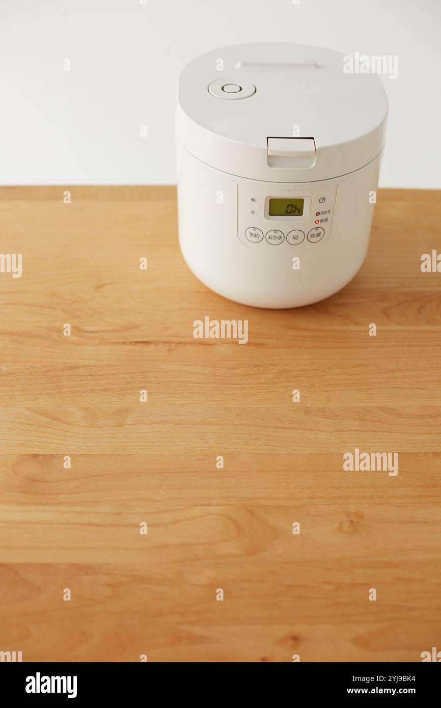 Rice cooker on wood grain table Stock Photo - Alamy
