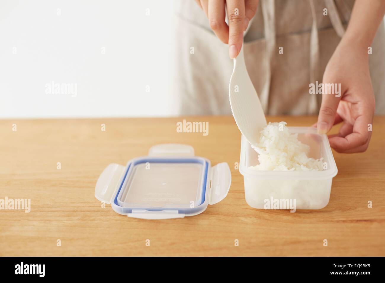 Woman packing white rice into Tupperware Stock Photo - Alamy