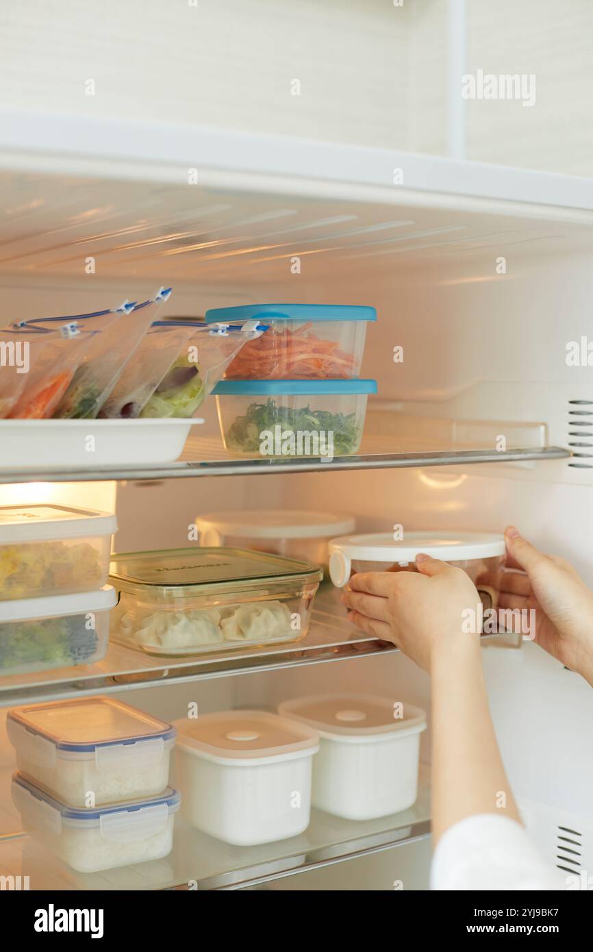 People's hands taking Tupperware out of the fridge Stock Photo - Alamy