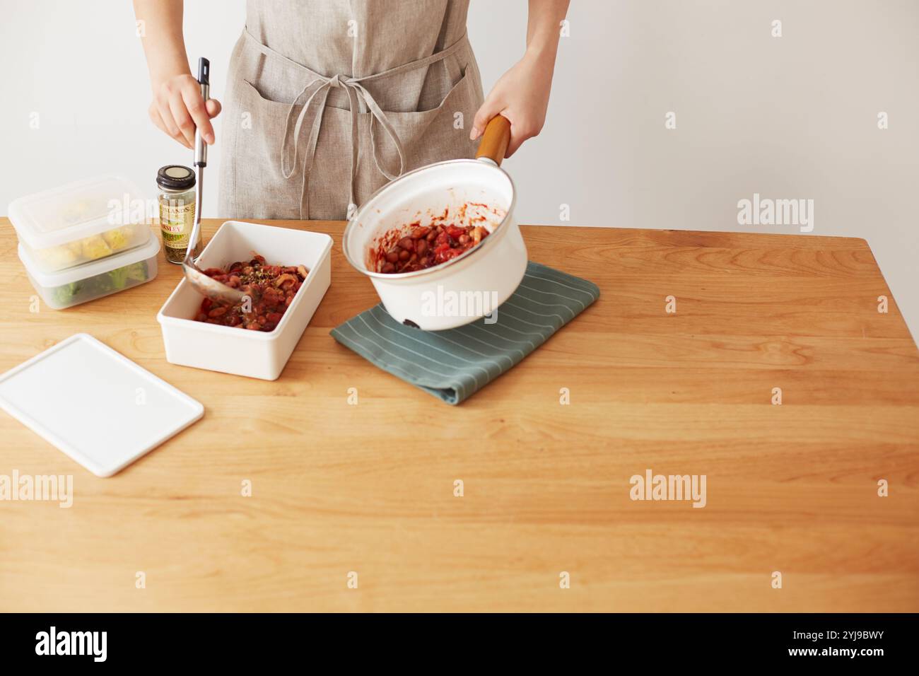Woman transferring food to Tupperware Stock Photo - Alamy