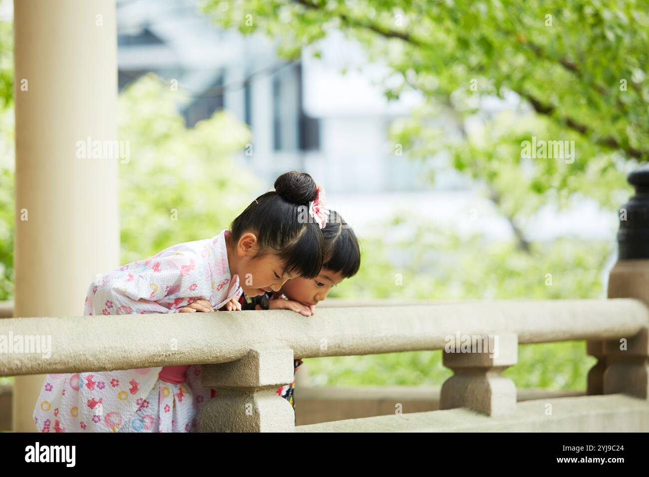 Girl in yukata peeking out from high column and looking down Stock ...