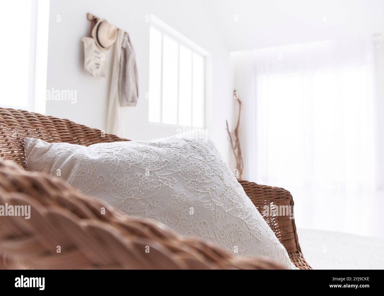 White cushion above rattan chair Stock Photo - Alamy