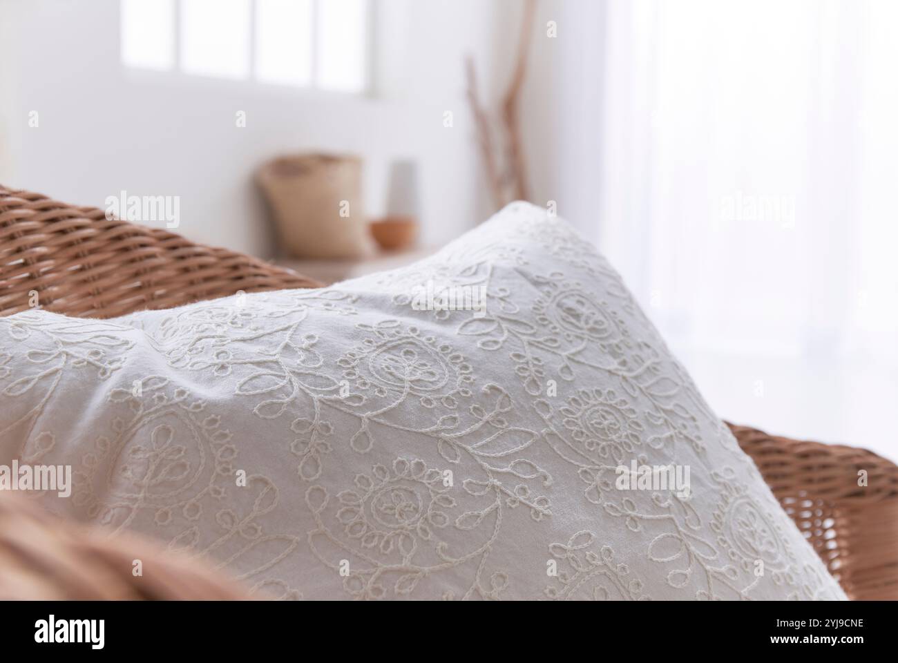 White cushion above rattan chair Stock Photo - Alamy