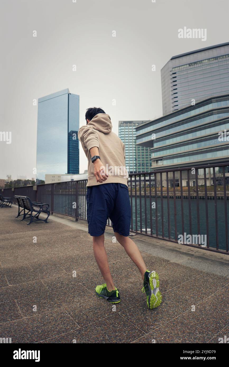 Man in back running wearing smartwatch Stock Photo - Alamy