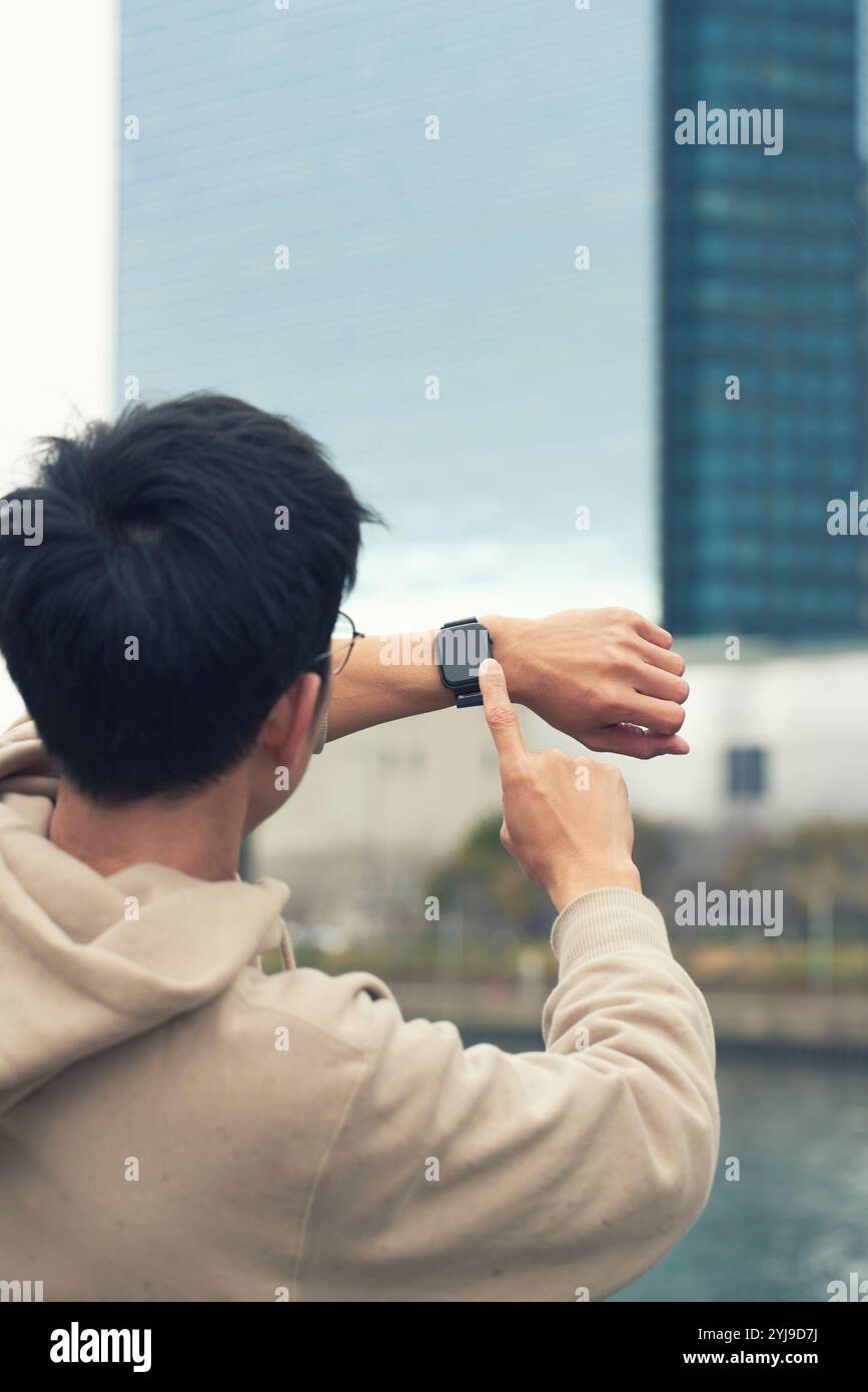 Rear view man checking his smartwatch Stock Photo - Alamy