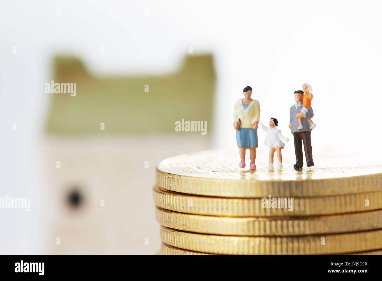 Miniature doll of a family on a coin Stock Photo - Alamy