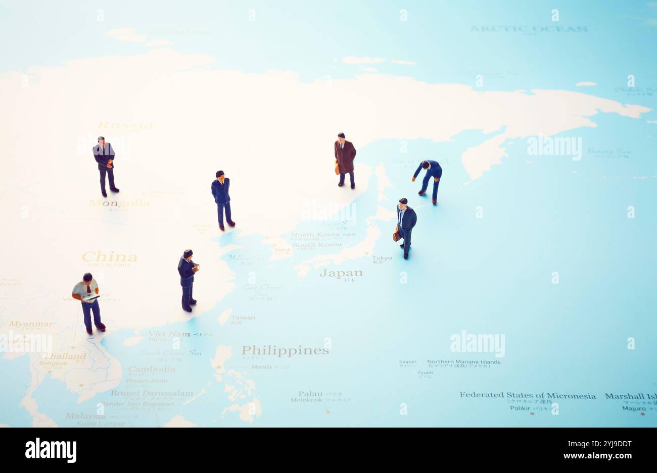 Miniature dolls standing on world map Stock Photo - Alamy