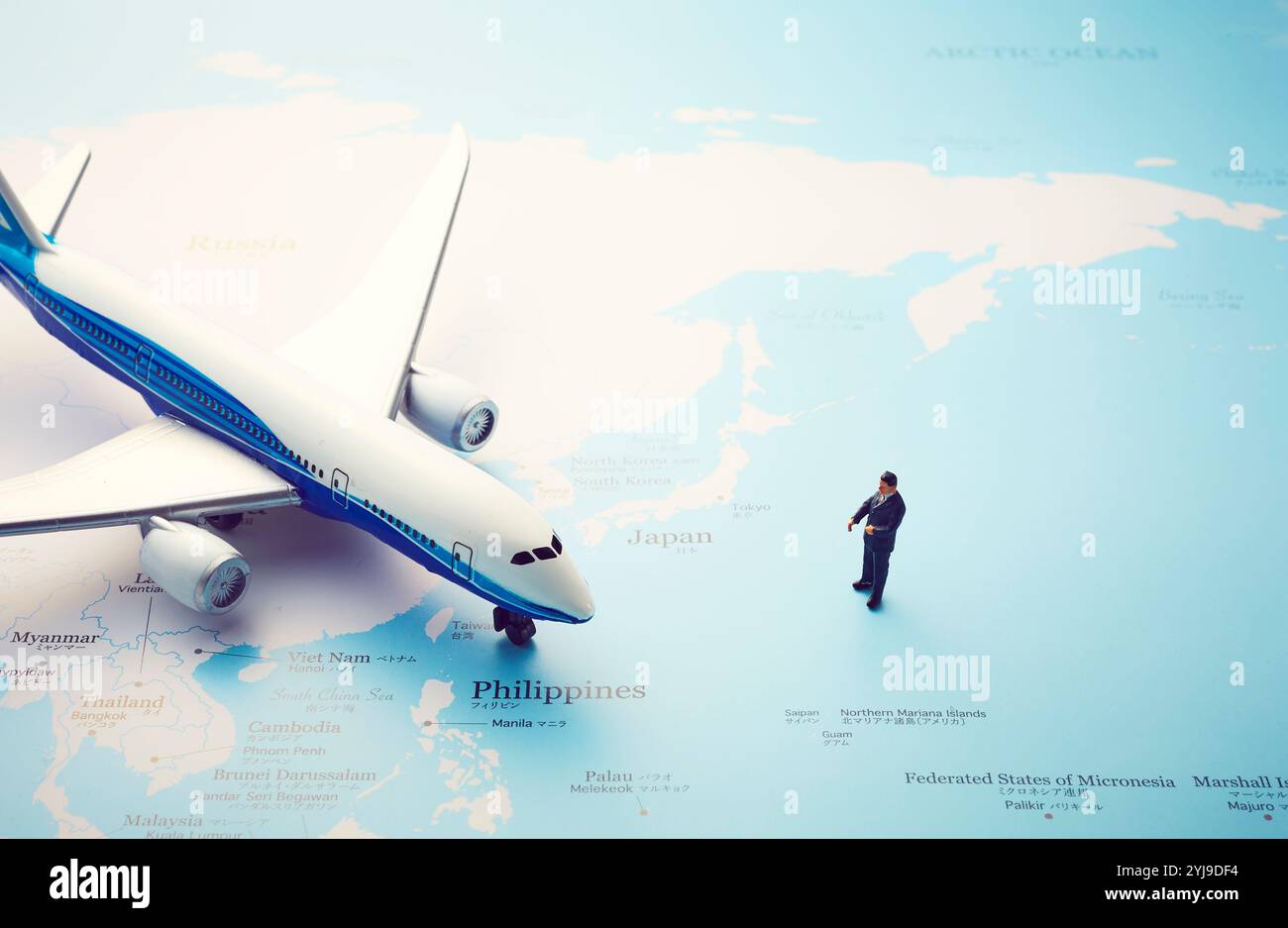 Miniature doll with an aeroplane on a world map Stock Photo - Alamy