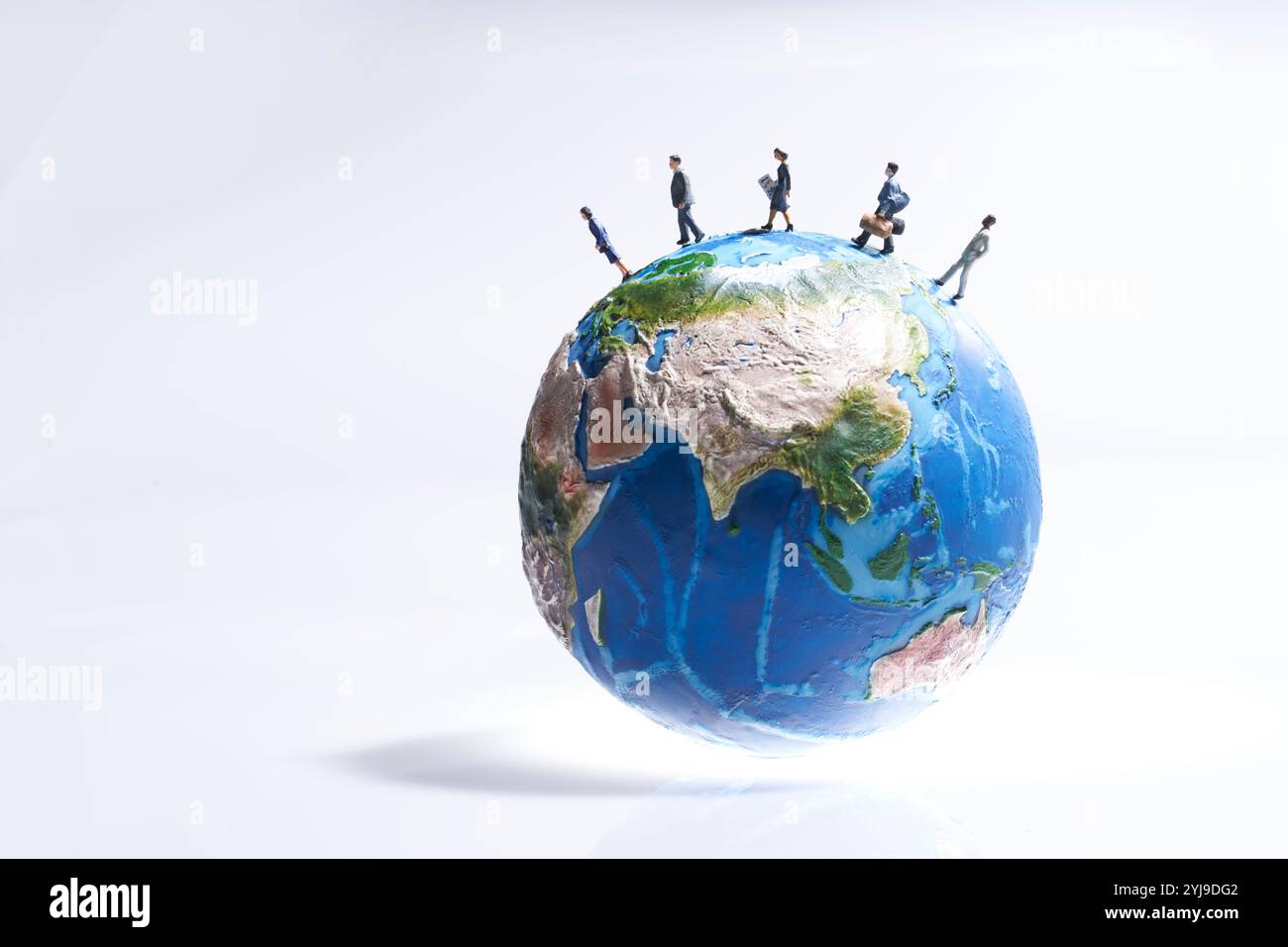 Miniature dolls travelling around the world with a model of the Earth ...