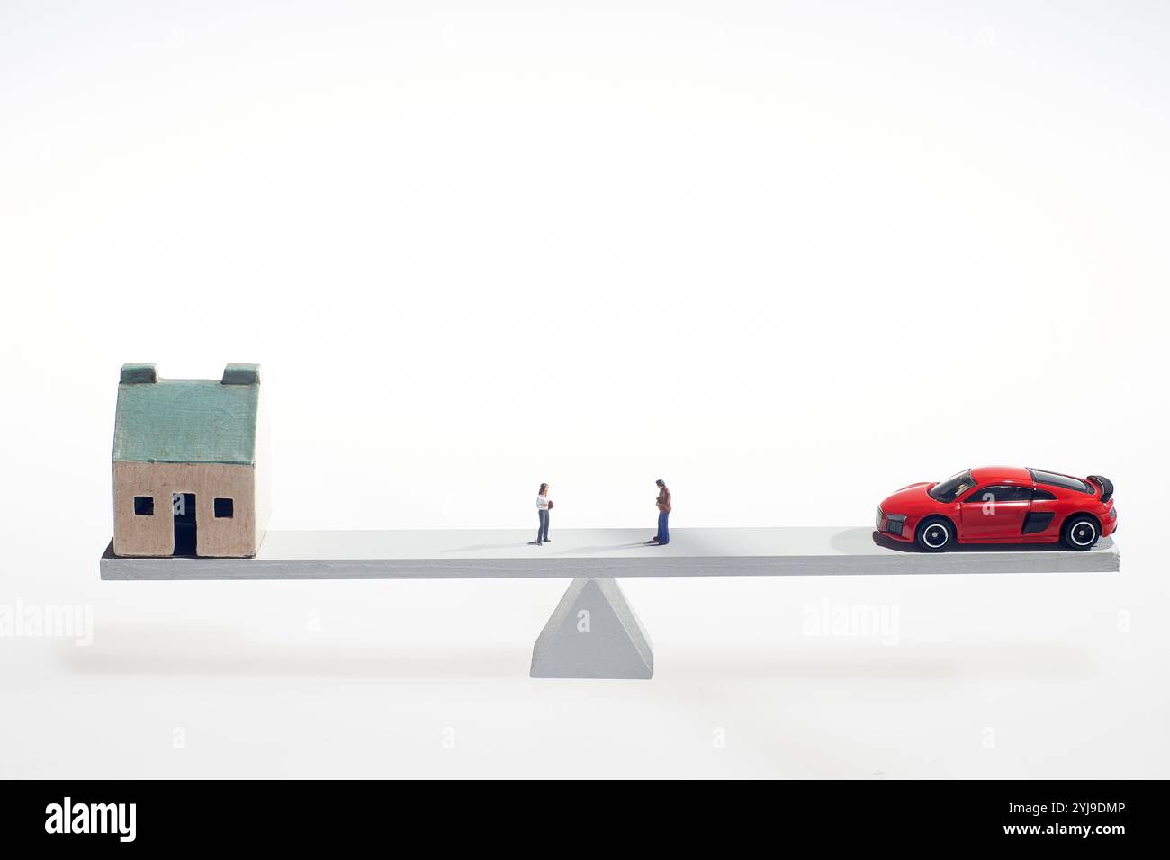 Miniature doll of a car, a house and a couple on a balance Stock Photo ...
