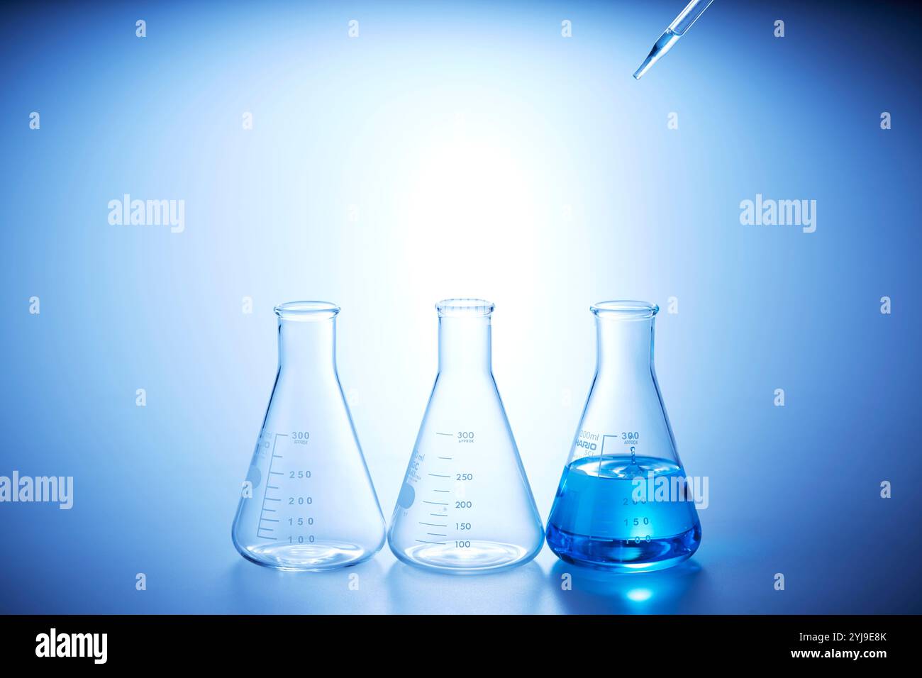 Three side-by-side triangular flasks filled with blue liquid Stock ...