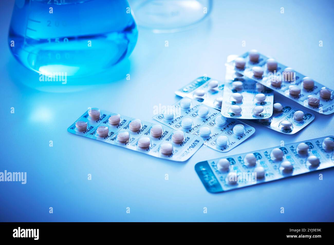 Glass container with blue liquid and pill pills Stock Photo - Alamy