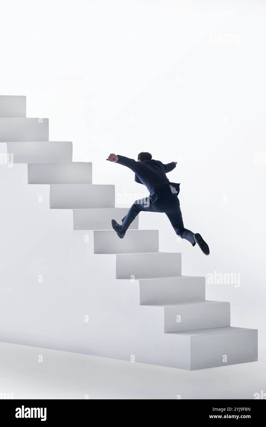 Back view of man in suit running up white stairs Stock Photo - Alamy