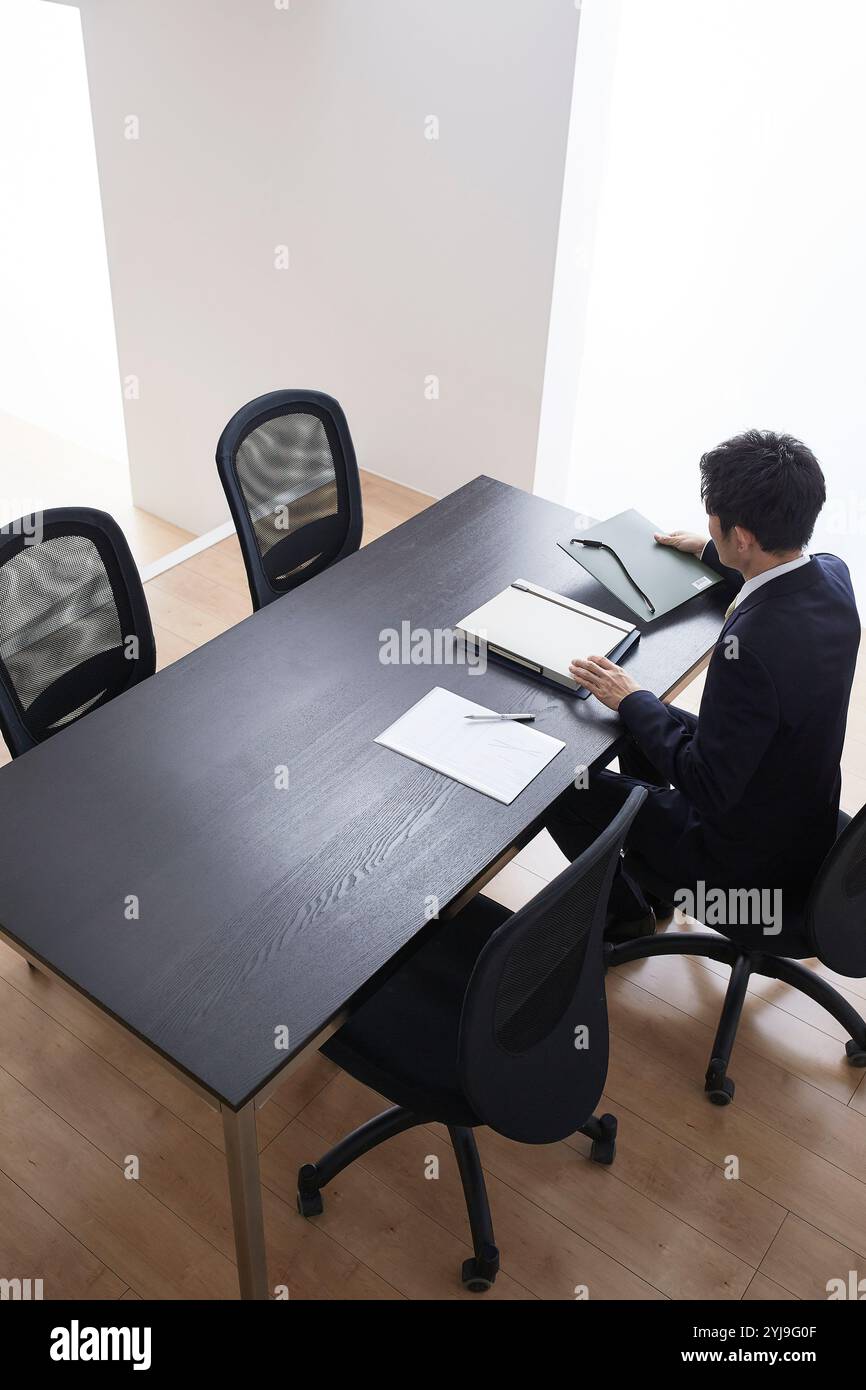Man sitting on chair in naturally decorated conference room Stock Photo ...