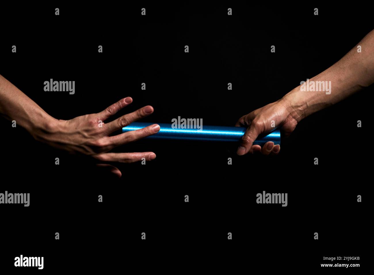 Male athlete passing the baton on black background Stock Photo - Alamy