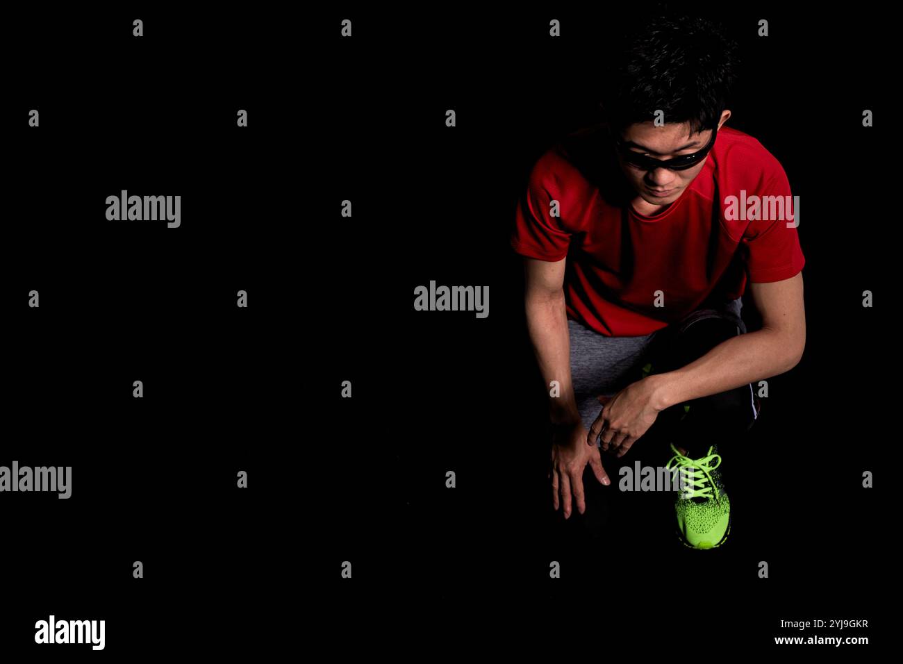 Male athlete crouching on black background Stock Photo - Alamy