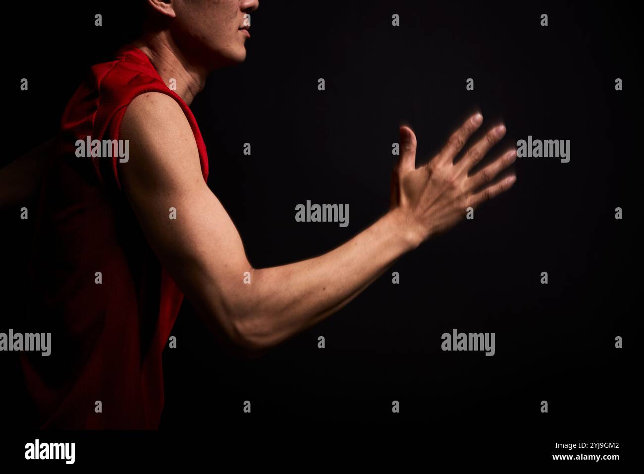 Male athlete waving his arms strongly against a black background Stock ...